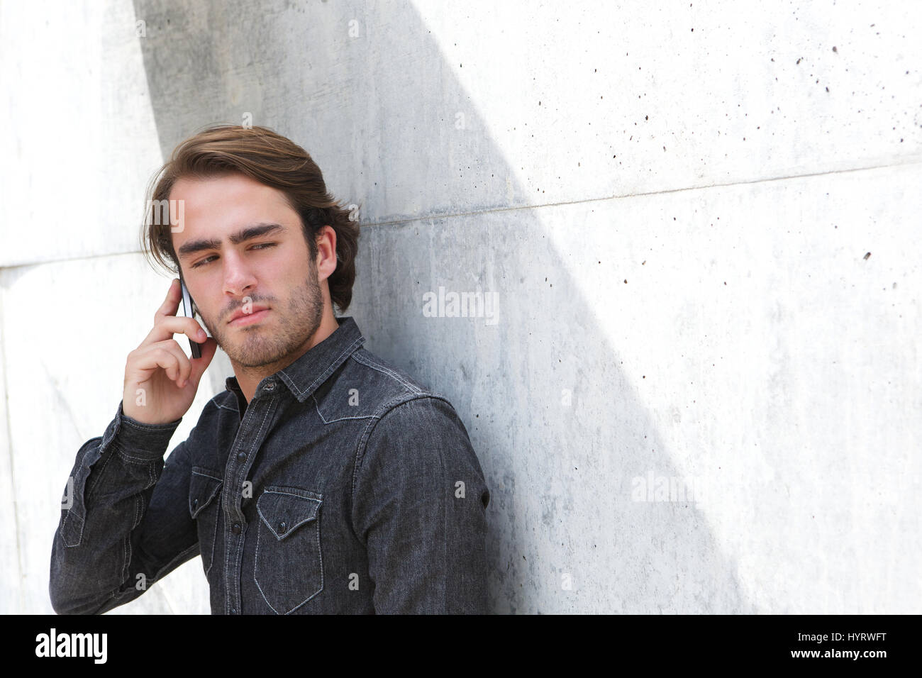 Close up portrait of a handsome young man calling with mobile phone ...
