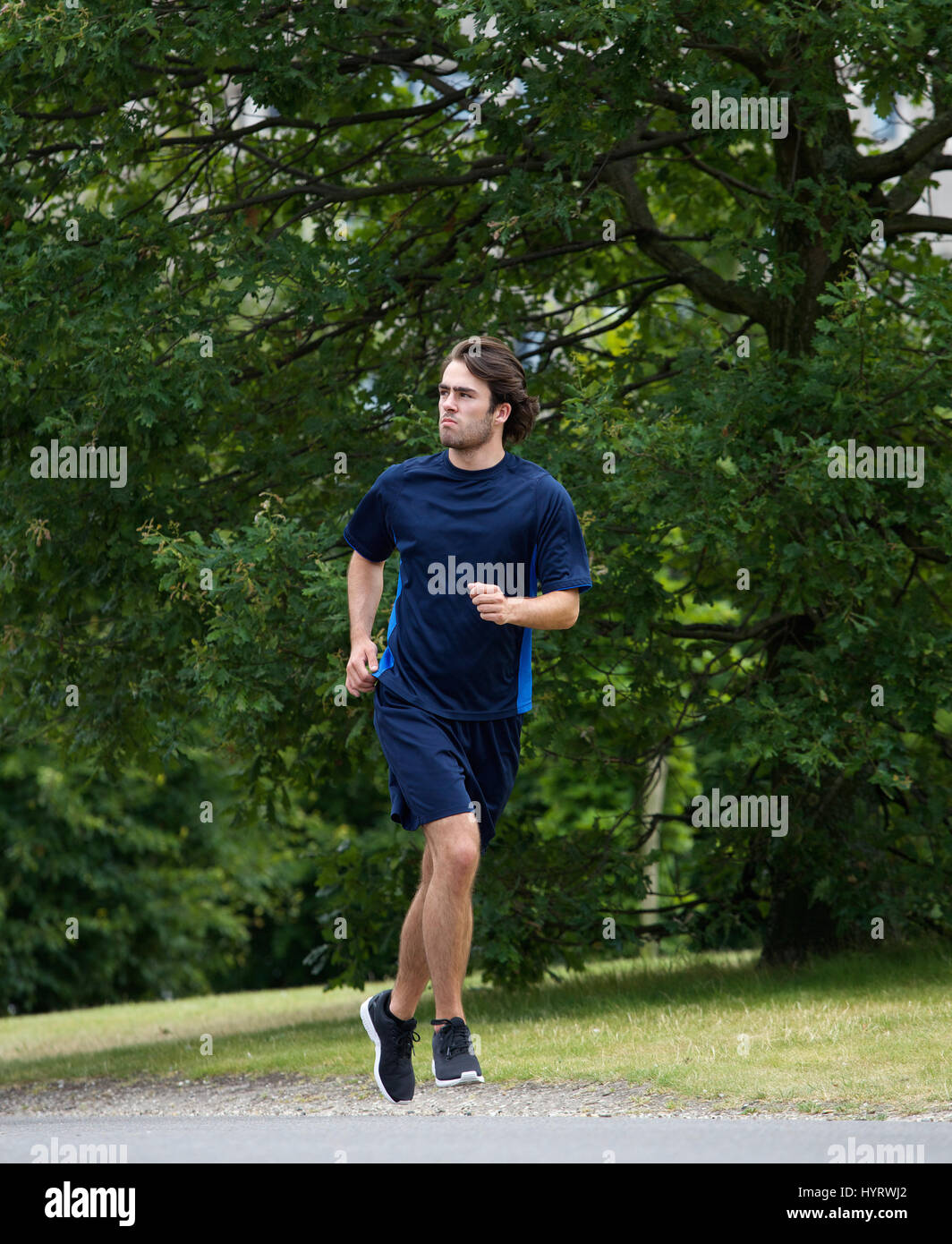 Young athletic man running outdoors in park Stock Photo - Alamy