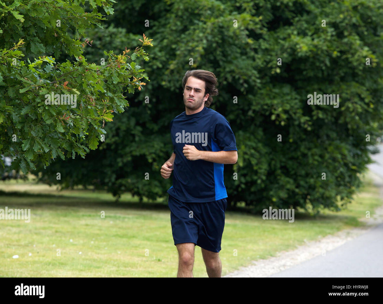 Healthy young man jogging outdoors in park Stock Photo - Alamy