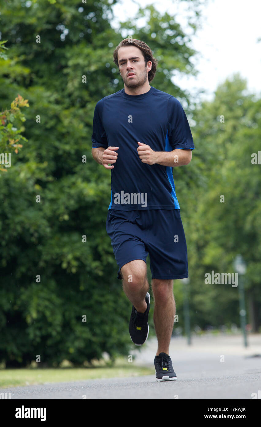Full length of a young man running outdoors Stock Photo - Alamy