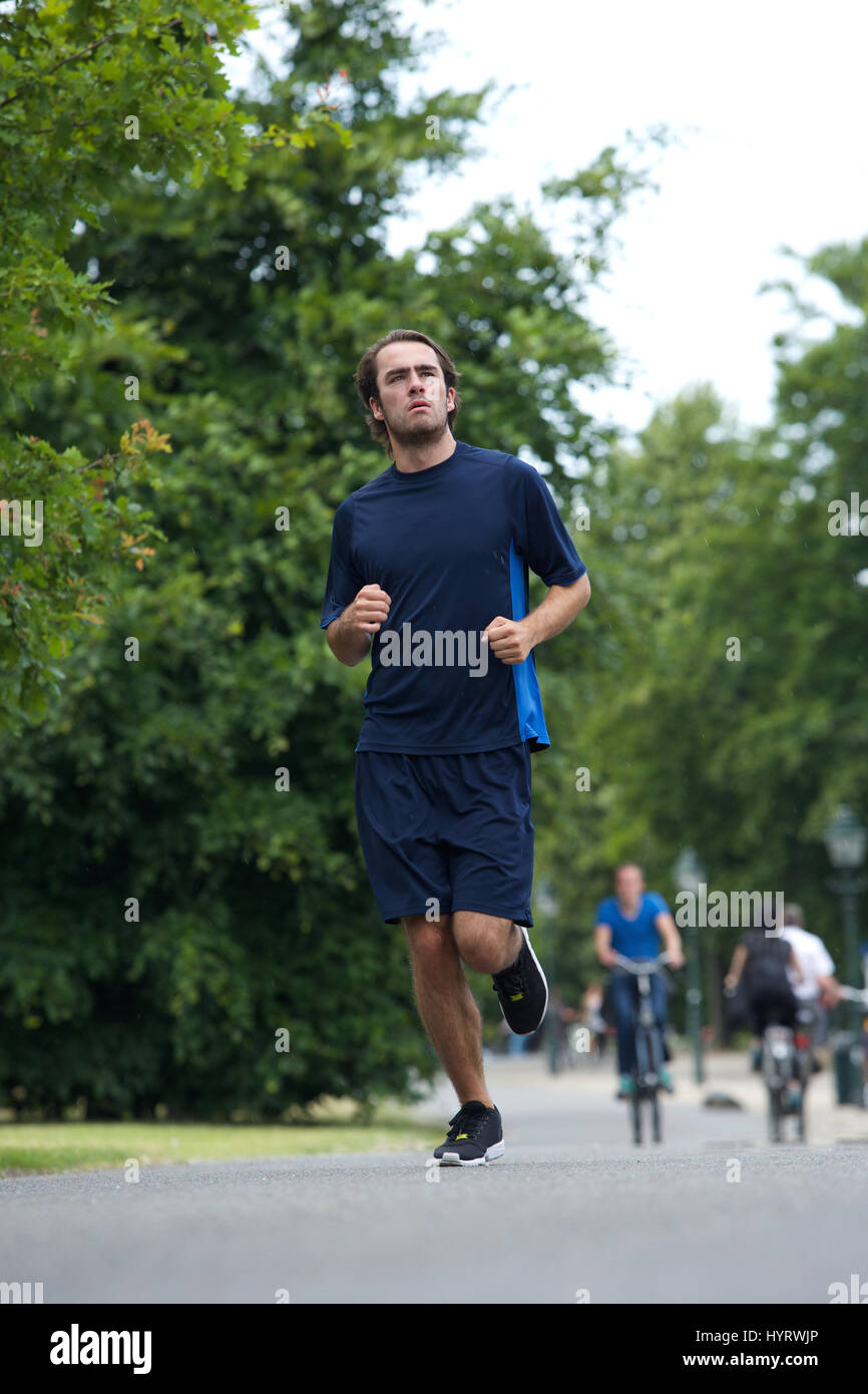 Full body young man running in the park Stock Photo - Alamy