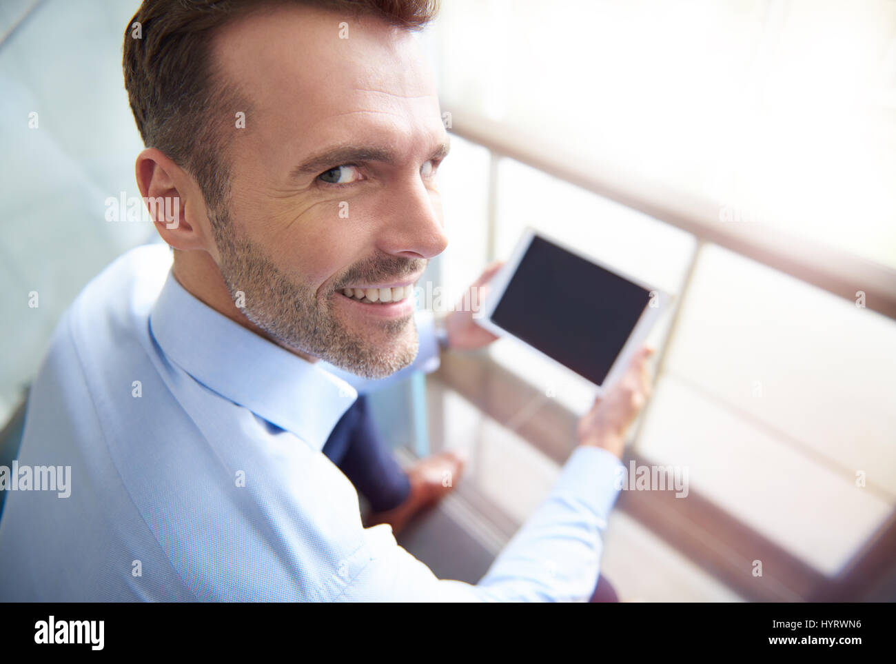 Man with digital tablet looking at camera Stock Photo - Alamy