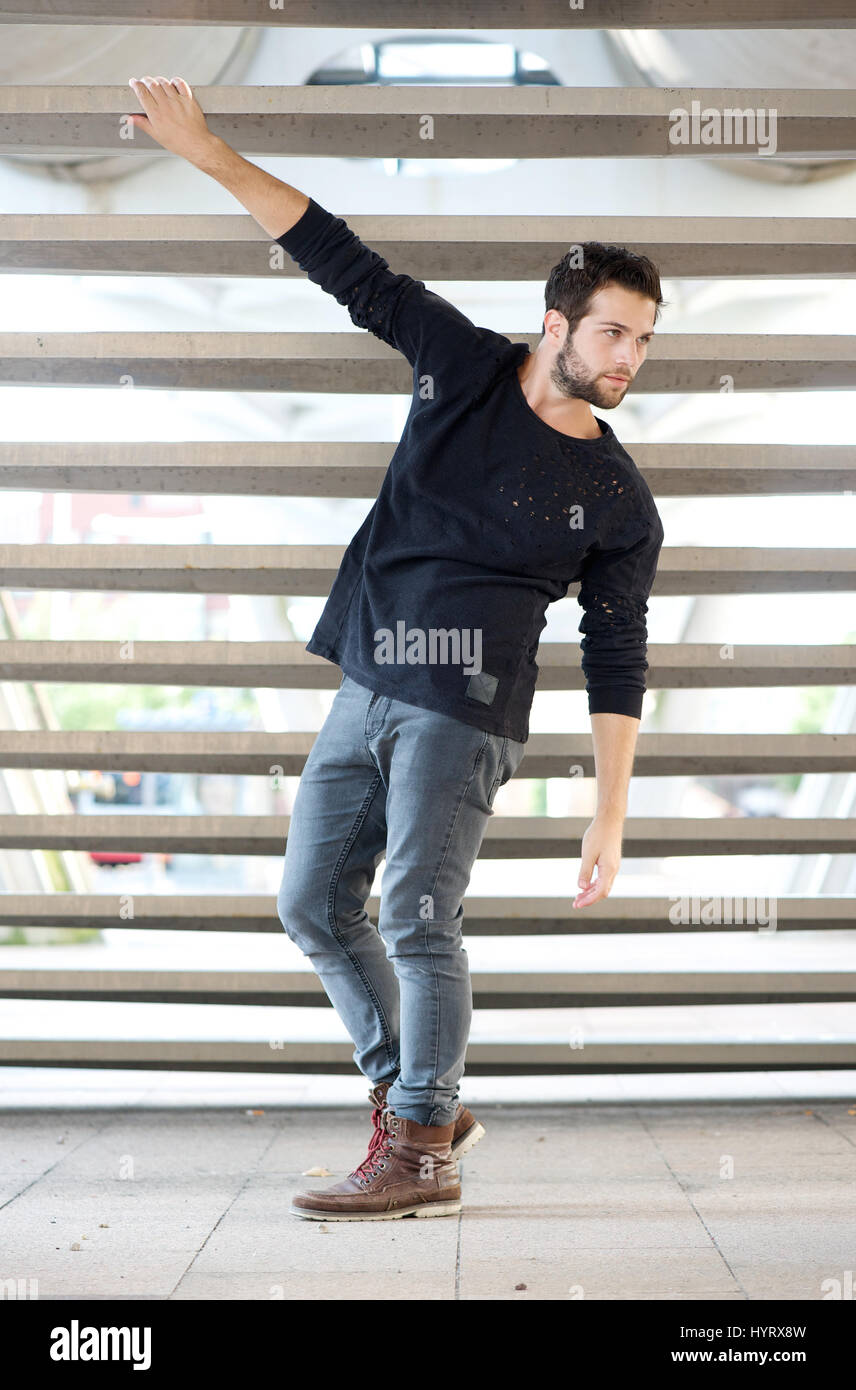 Full length portrait of a male fashion model in black clothing posing ...