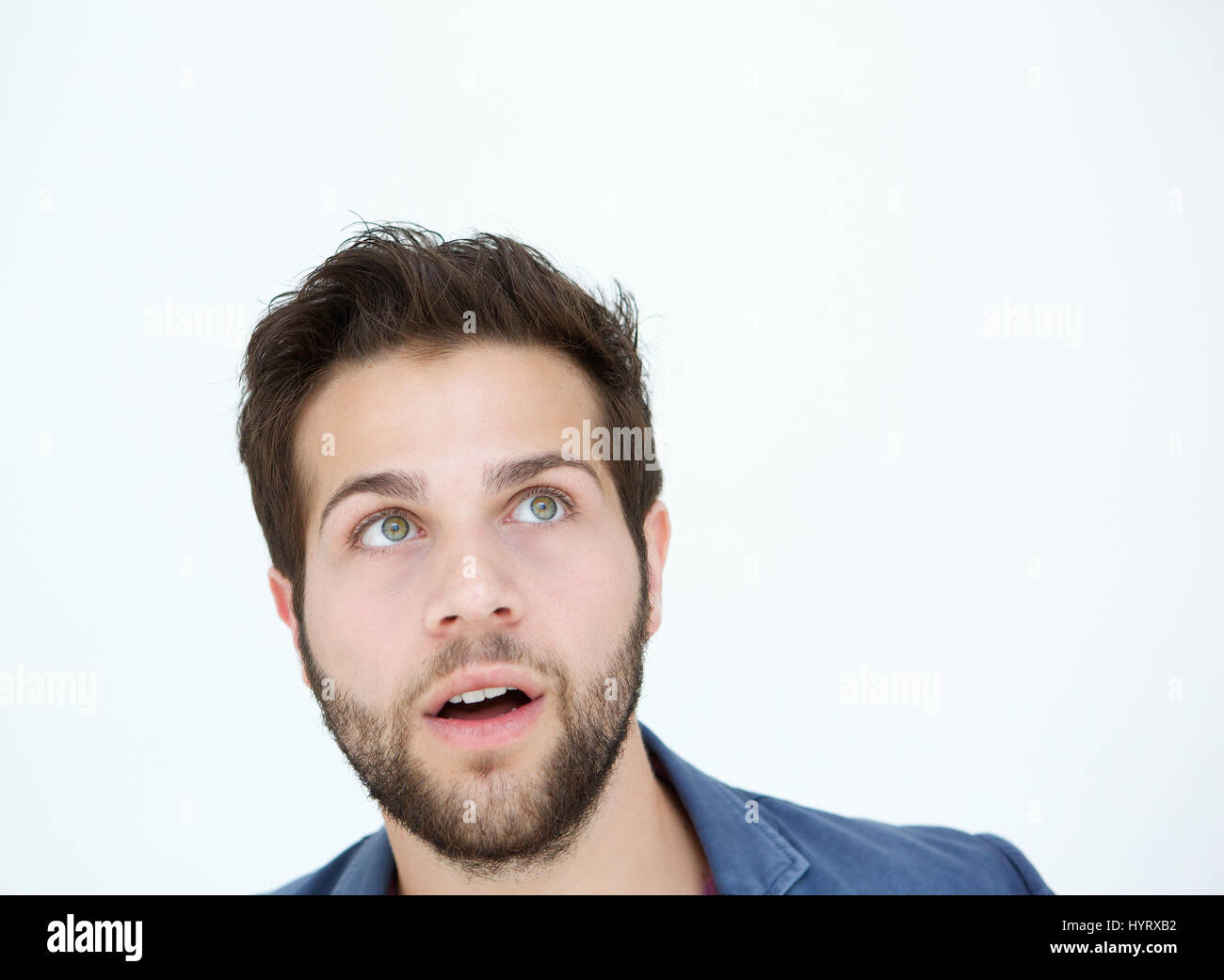 Close up portrait of a young man looking up with surprised expression ...