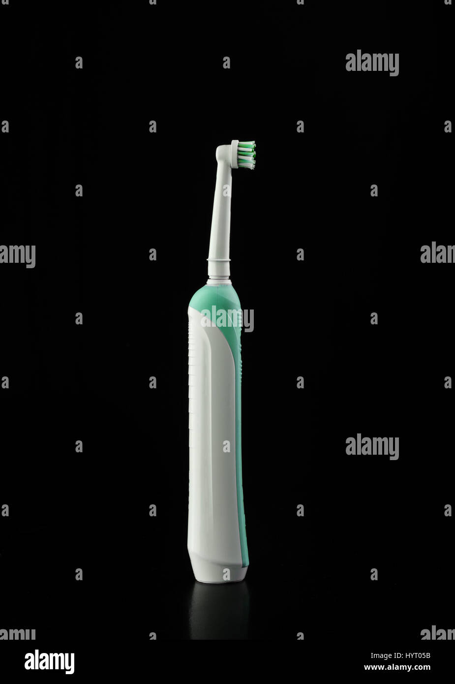 Modern electric toothbrush with used head vertical on a black ...