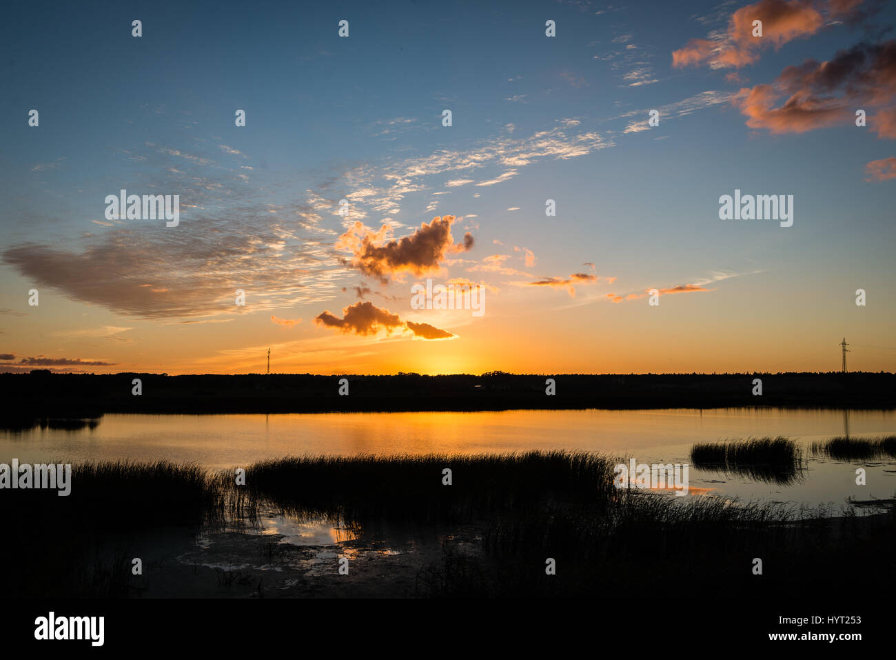 Beautiful summer sunset at the river with blue sky, red and orange ...