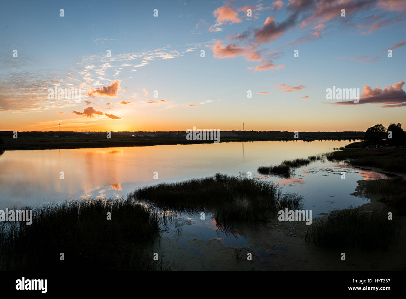 Beautiful summer sunset at the river with blue sky, red and orange ...