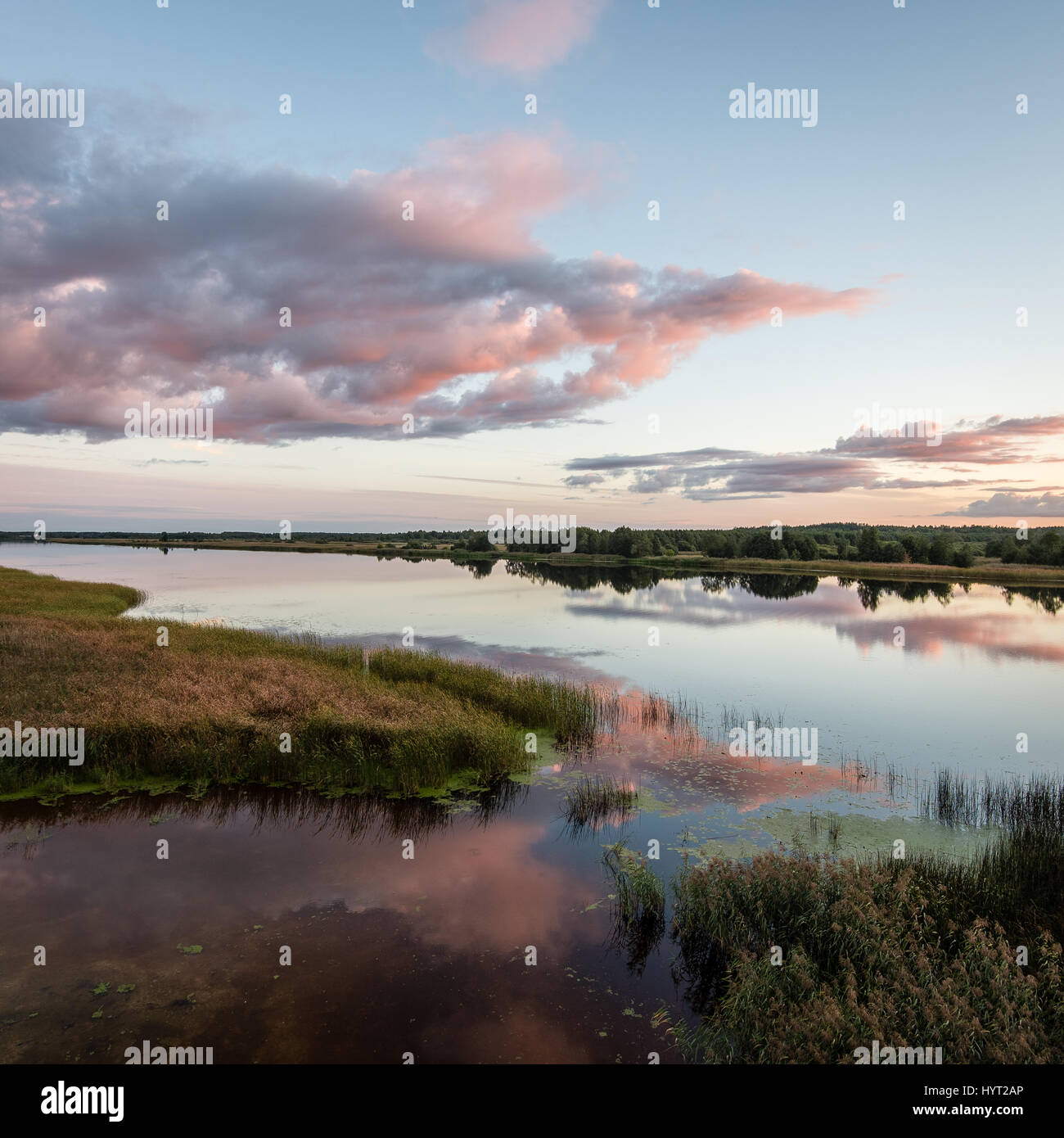 Beautiful summer sunset at the river with blue sky, red and orange ...