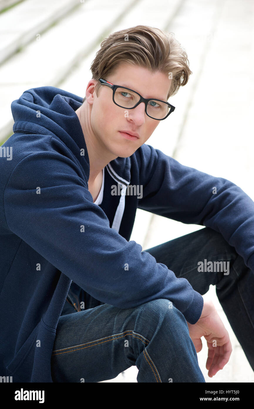 Close up portrait of a cool young guy sitting outdoors Stock Photo - Alamy