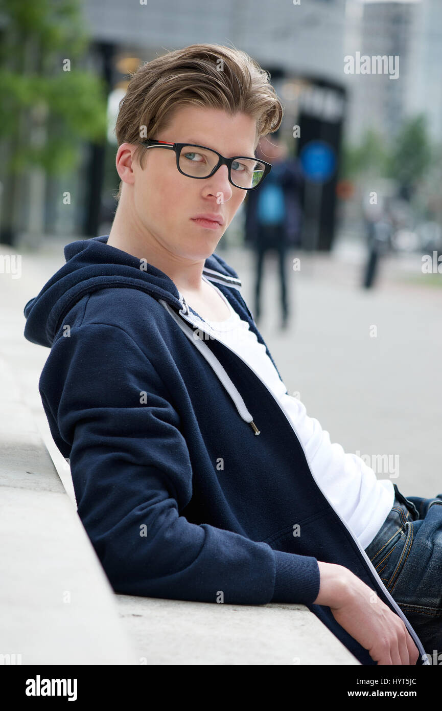 Close up portrait of a cool young guy with glasses posing outdoors ...