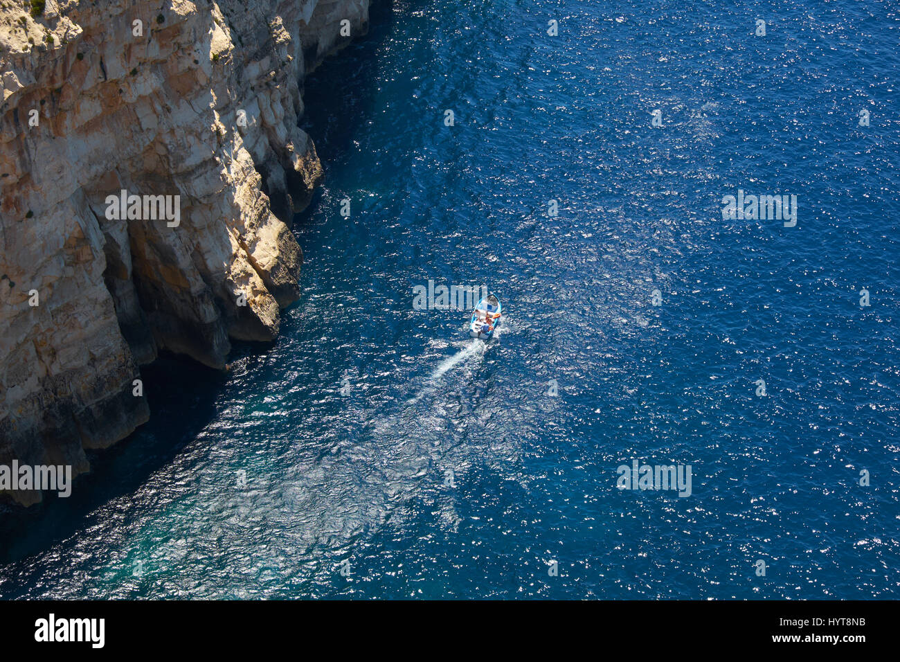 Touristic boat under steep cliff over Mediterranean sea on south part ...