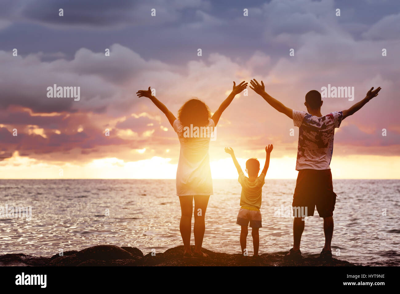 Happy family with son greetings sunset and sea Stock Photo - Alamy