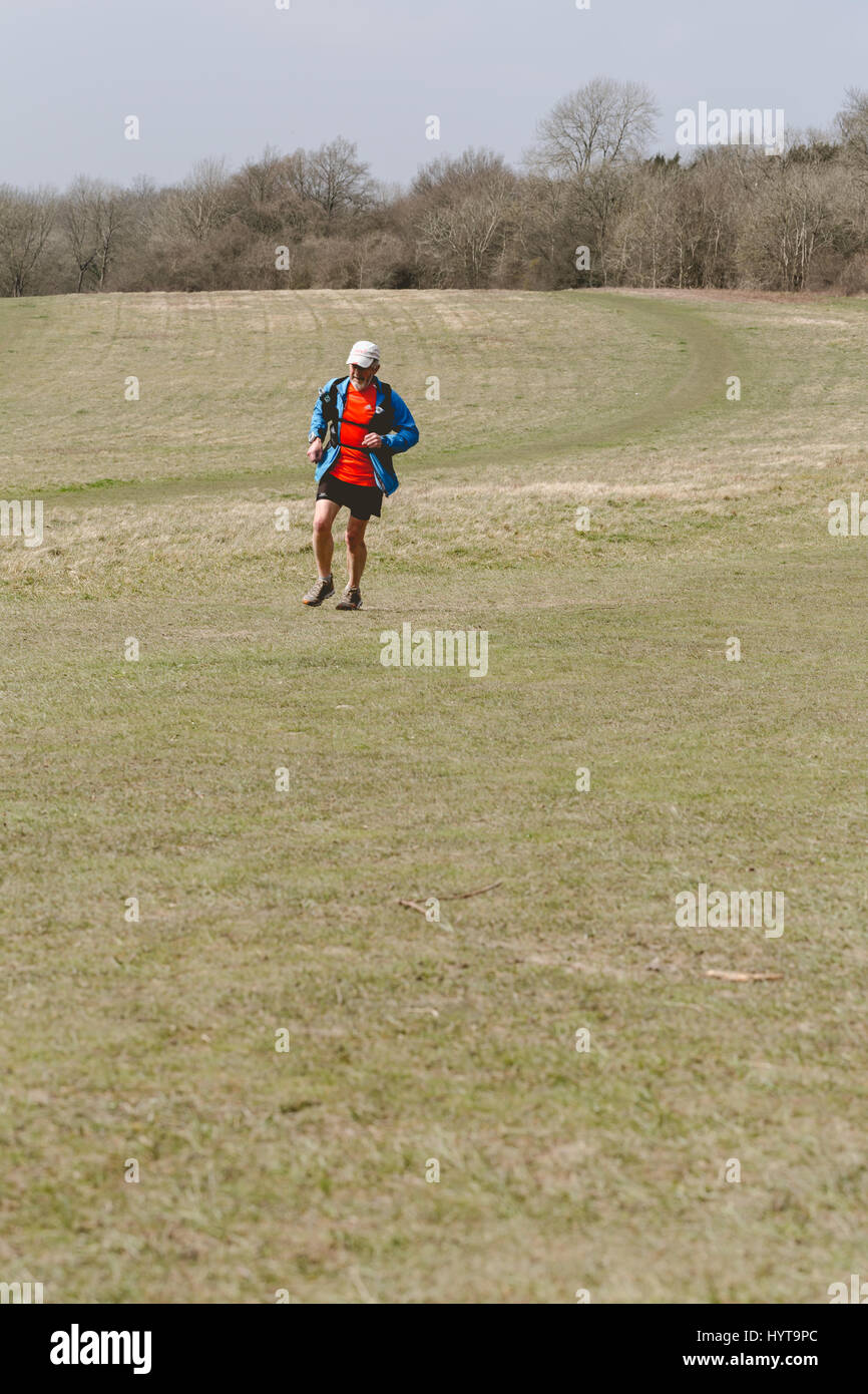 Older man with rucksack running through Surrey fields and meadows Stock ...