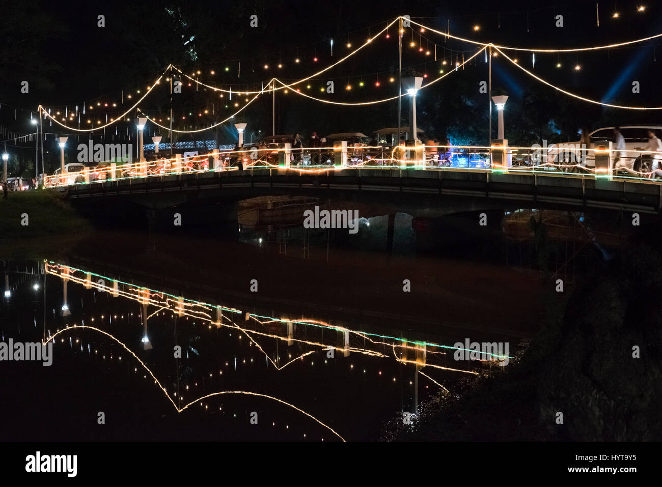 Horizontal view of people and traffic crossing a bridge in Siem Reap at ...