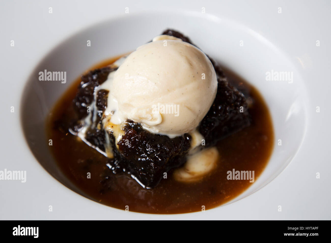 Sticky toffee pudding served with caramel sauce and ice cream. The ...