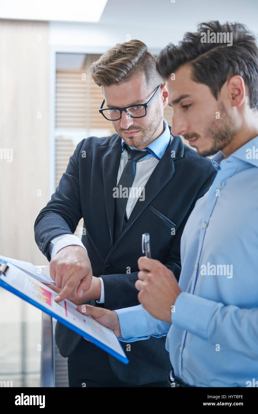 Two men analyzing some documents Stock Photo - Alamy