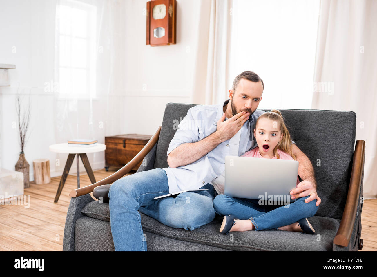 Shocked father and daughter using laptop at home Stock Photo - Alamy
