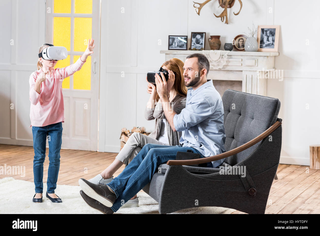 Happy family using virtual reality headsets together at home Stock ...