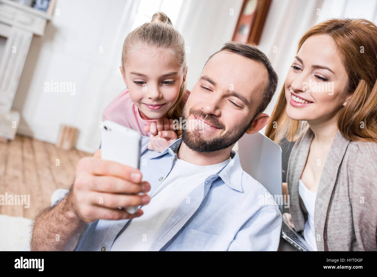 Portrait of happy family using smartphone at home Stock Photo - Alamy