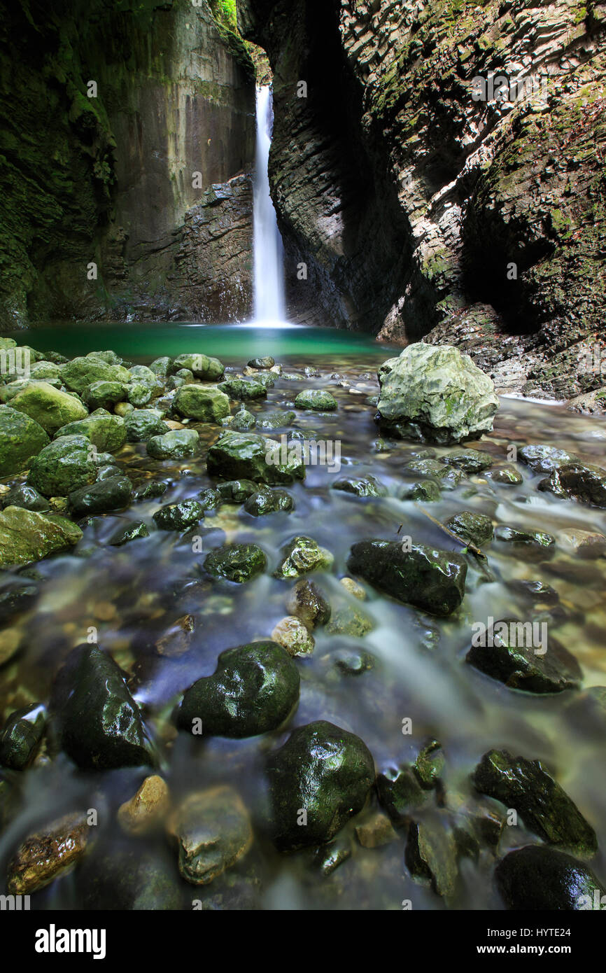 Alpine spring with romantic waterfall falling deep into a narrow gorge ...