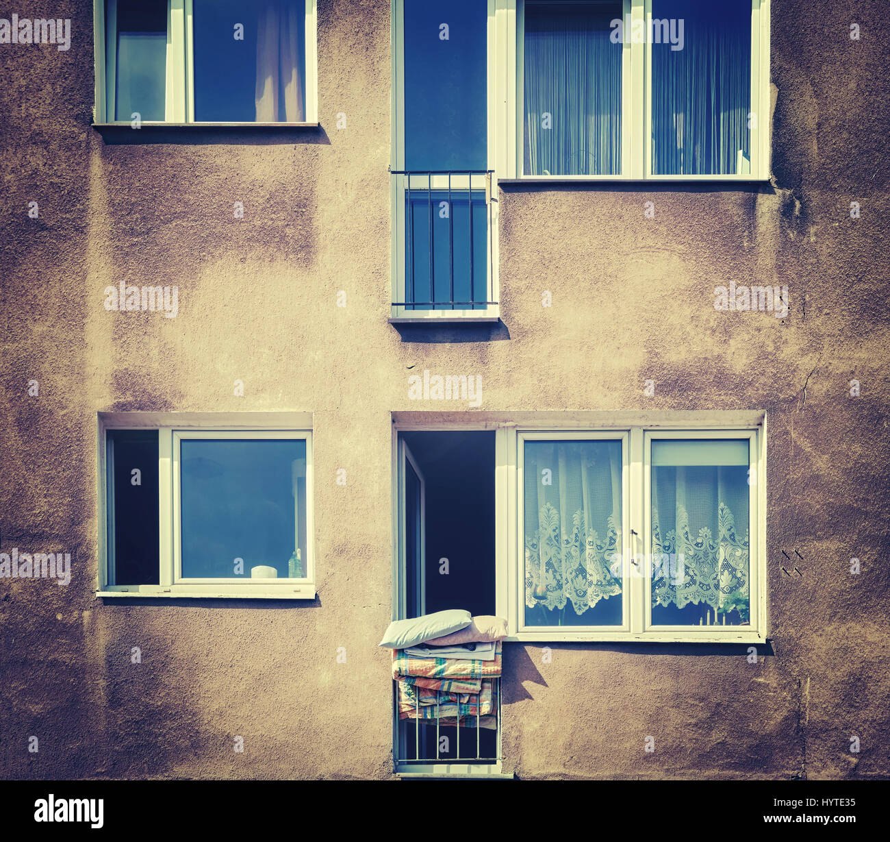 Vintage stylized old apartment facade with drying bedding hanging out ...