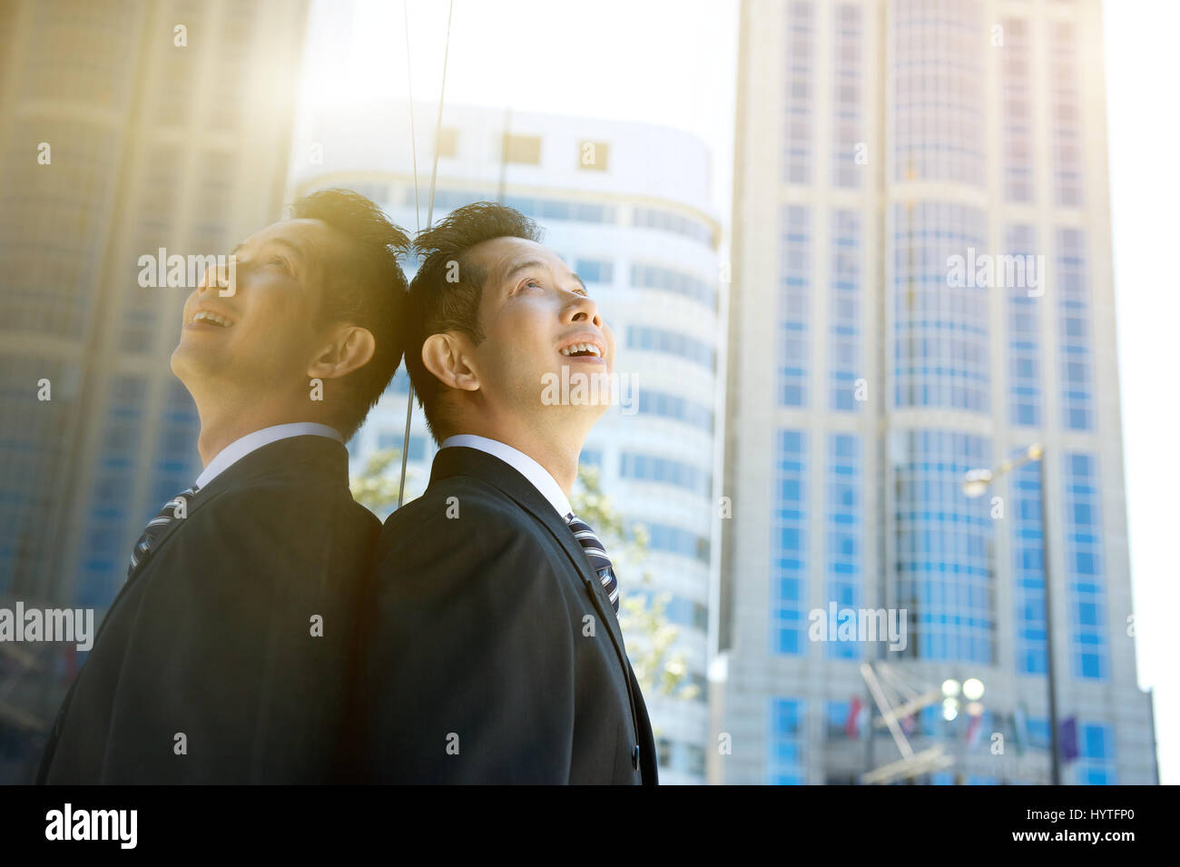 Close up portrait of a smiling businessman looking up at buildings in ...