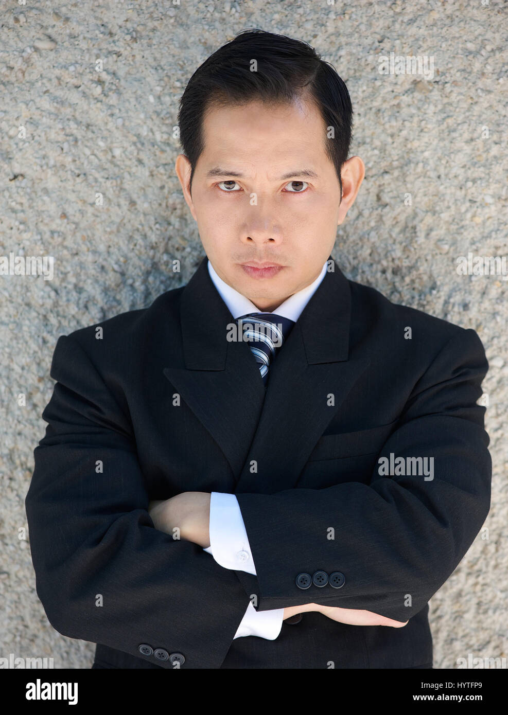 Close up portrait of a businessman posing with arms crossed and angry ...
