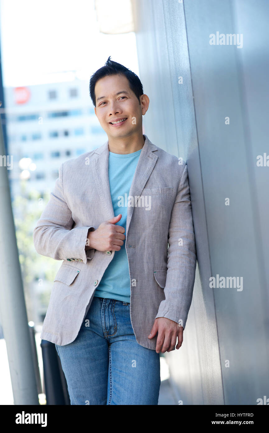 Portrait of a charming asian man smiling outdoors Stock Photo - Alamy