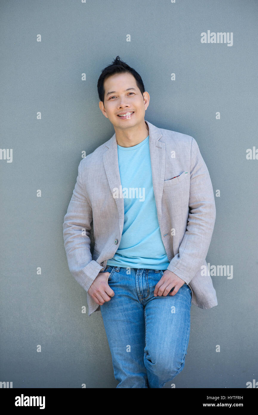 Portrait of a cool asian man smiling outdoors Stock Photo - Alamy