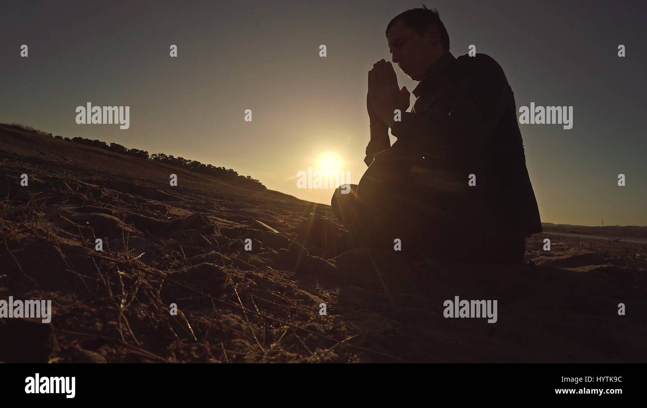 Man praying god sunset sitting hi-res stock photography and images - Alamy