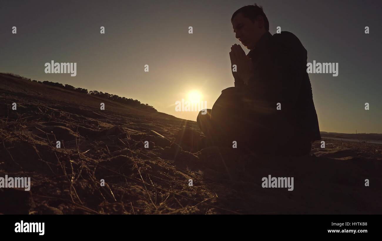 Man praying god sunset sitting hi-res stock photography and images - Alamy