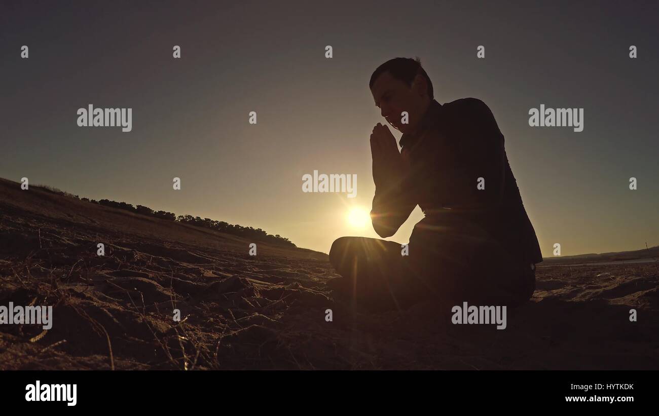 Man praying at sunset god sitting silhouette sun sunlight the religion ...