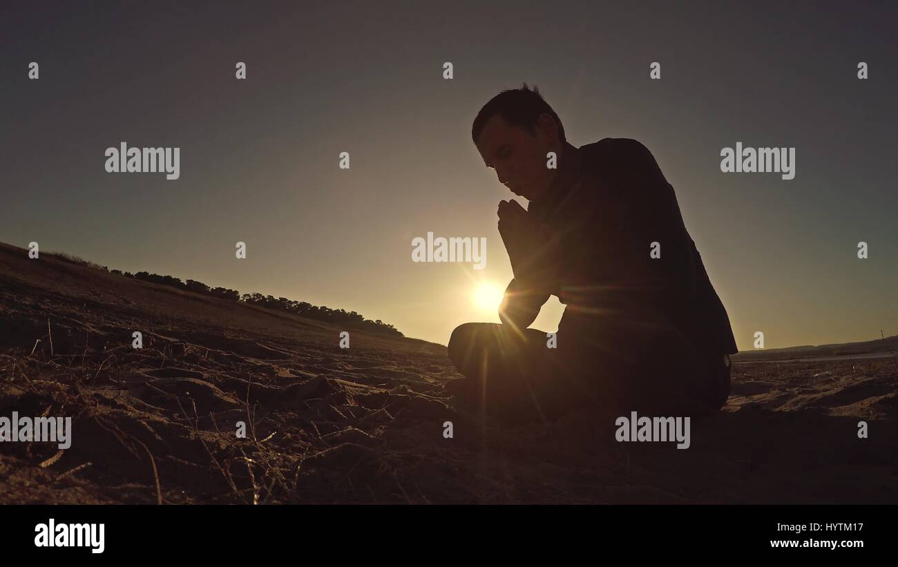 Man praying god sunset sitting hi-res stock photography and images - Alamy