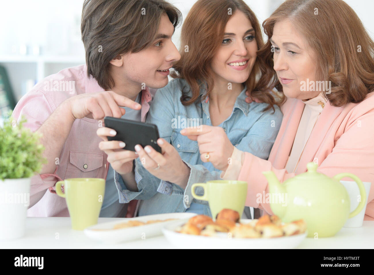 Portrait of happy family using mobile phone together Stock Photo - Alamy