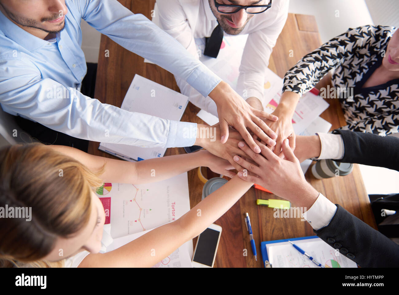 Stack of human hands above the table Stock Photo - Alamy