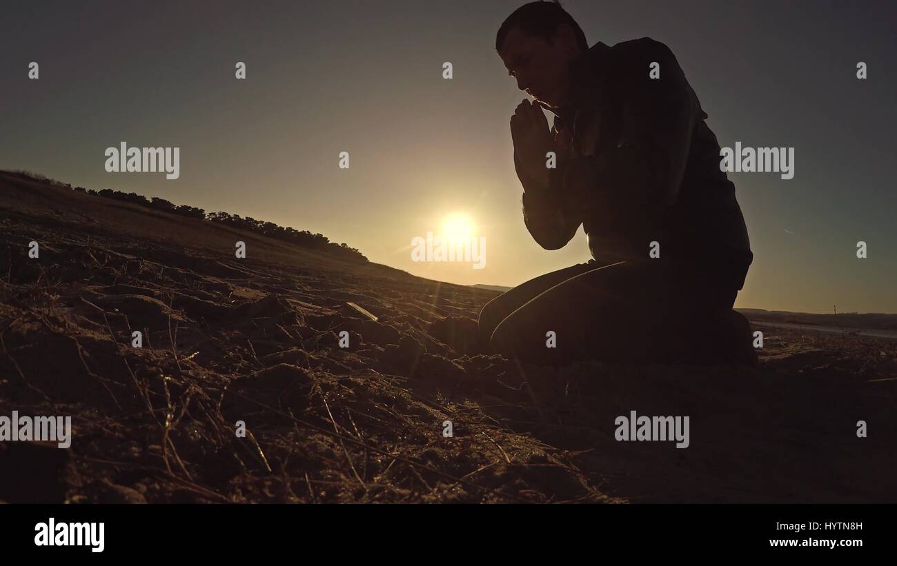 Man praying god sunset sitting hi-res stock photography and images - Alamy