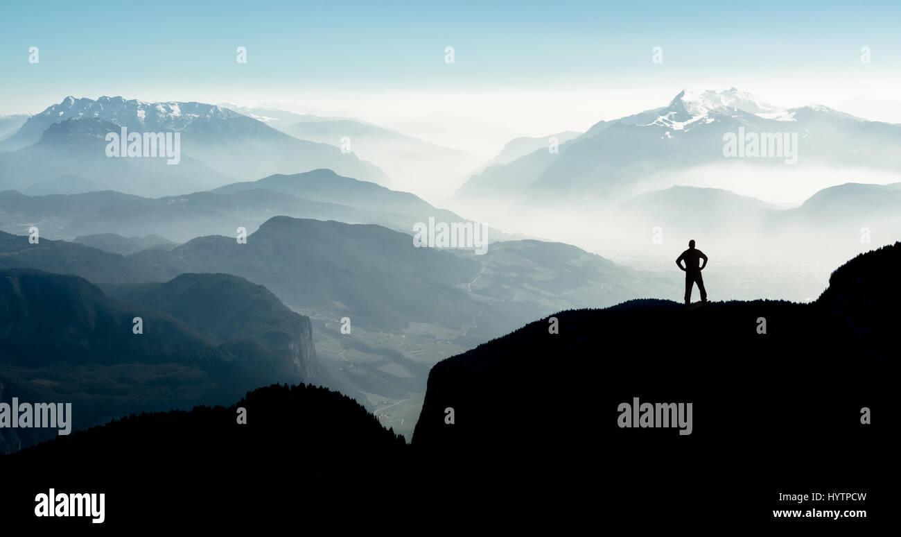 Spectacular mountain ranges silhouettes. Man reaching summit enjoying ...
