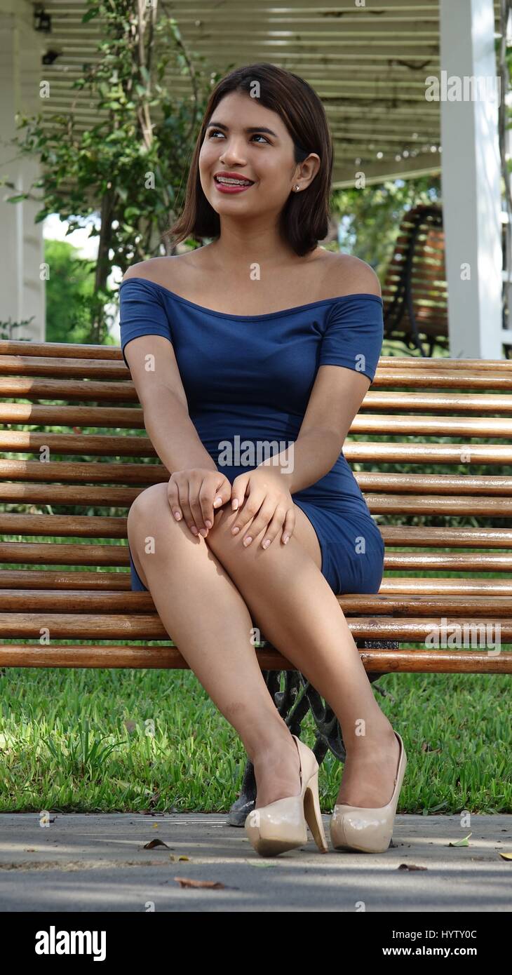 Young Woman Sitting On Park Bench Stock Photo - Alamy