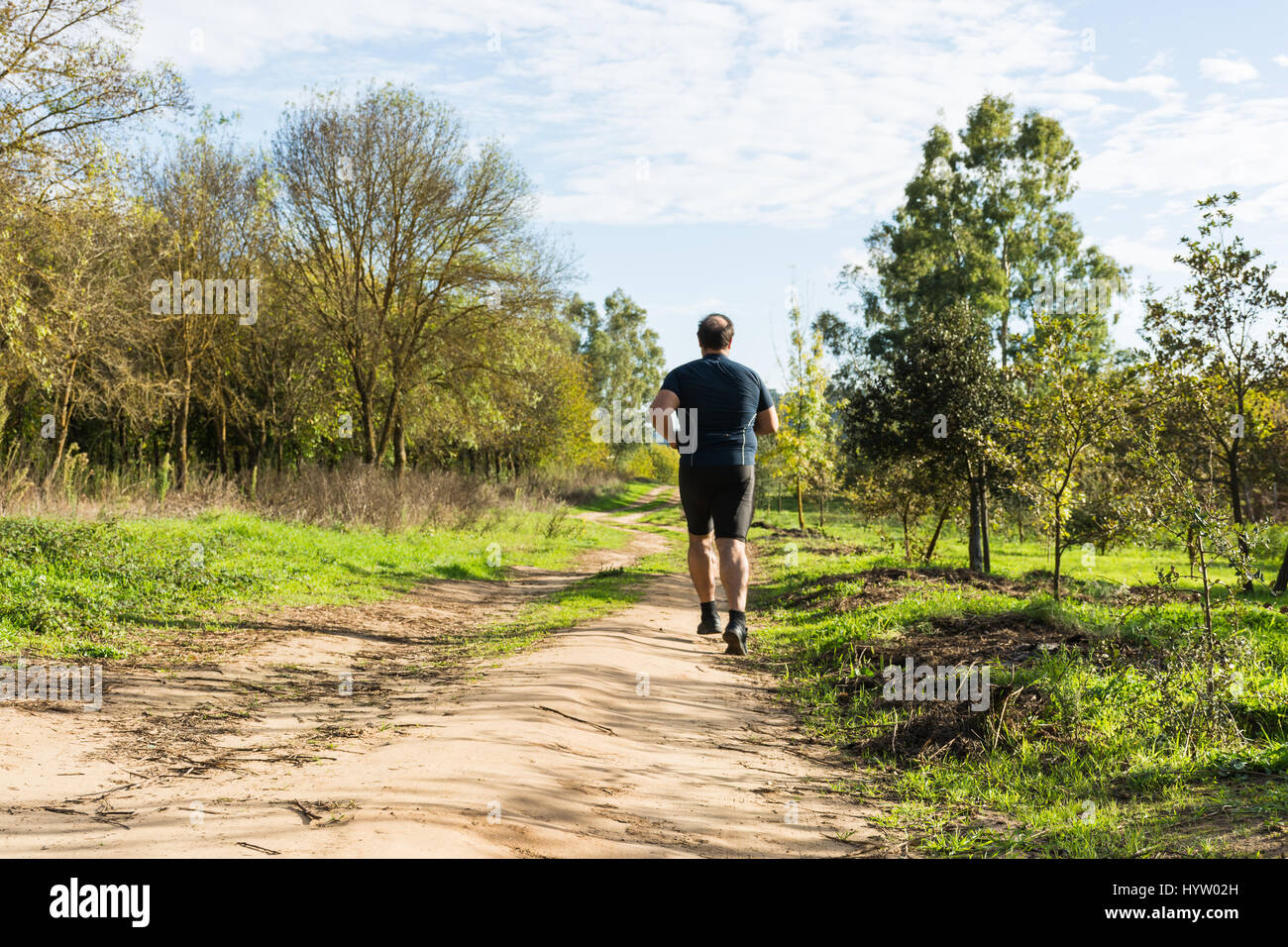 Big belly man jogging , exercising, doing cardio in the park , slightly ...