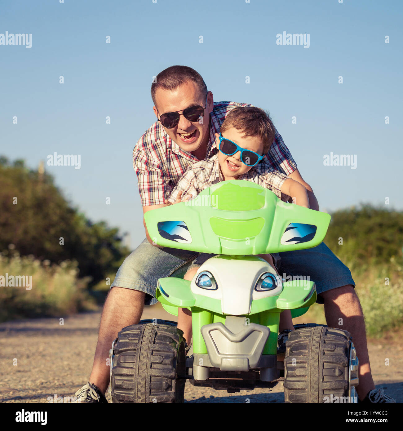 Father and son playing on the road at the day time. They driving on ...