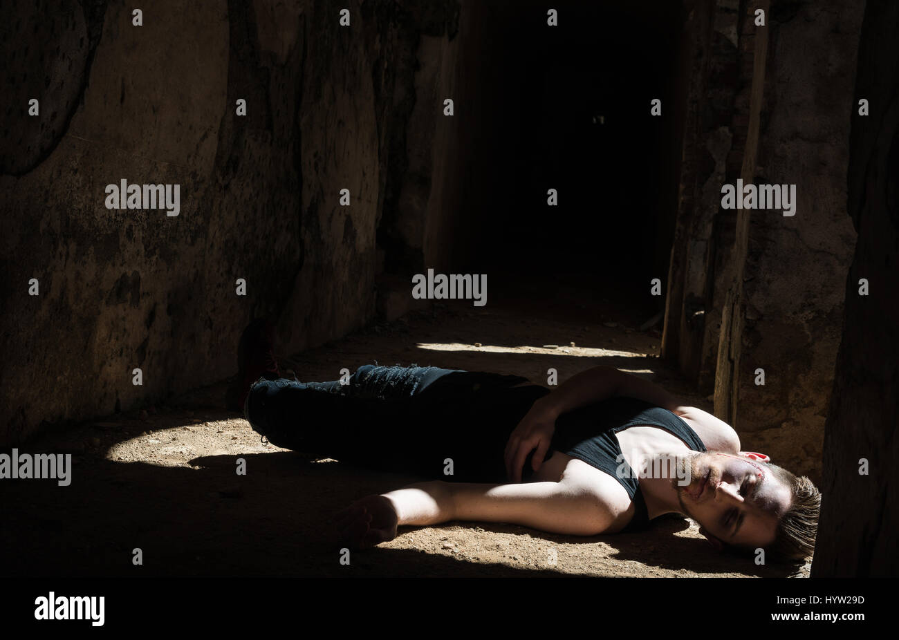 Unconscious man alone in abandoned place after being beaten Stock Photo ...
