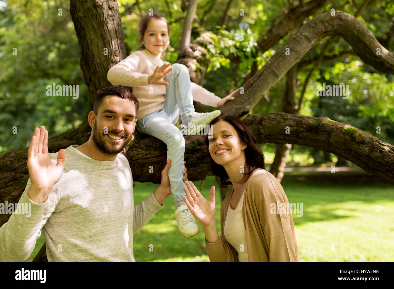 happy family in summer park waving hands Stock Photo - Alamy