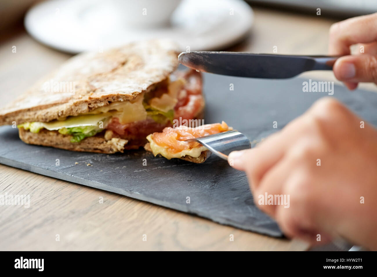 person eating salmon panini sandwich at restaurant Stock Photo - Alamy