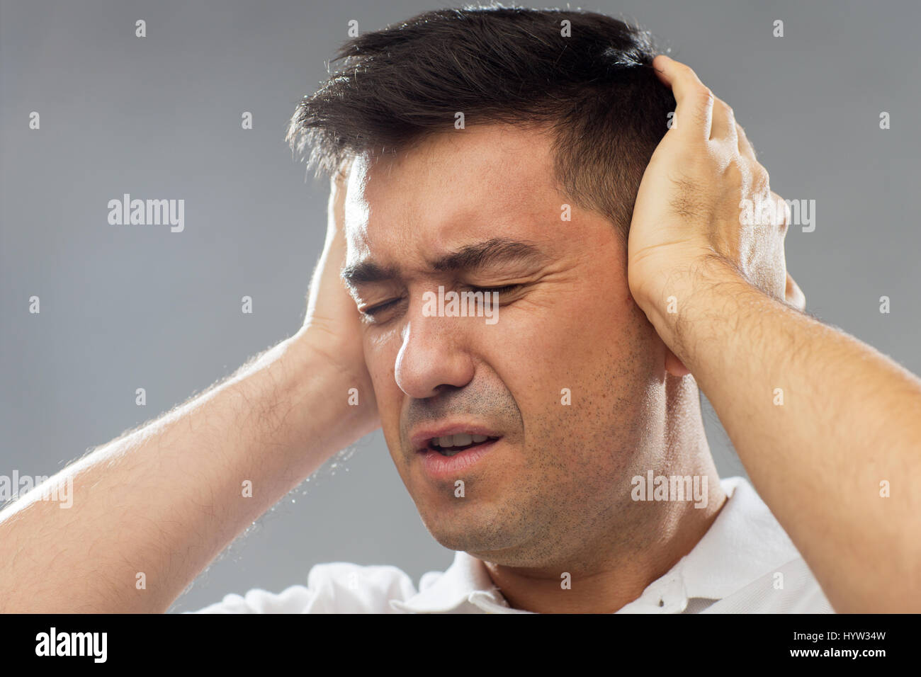 close up of man suffering from noise closing ears Stock Photo - Alamy