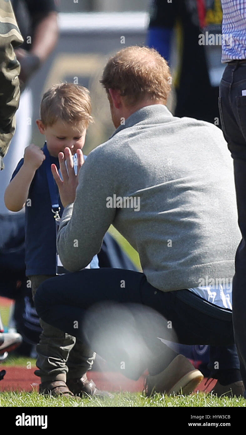 Prince Harry plays with Harry Phillips, 2, as he watches the UK team ...