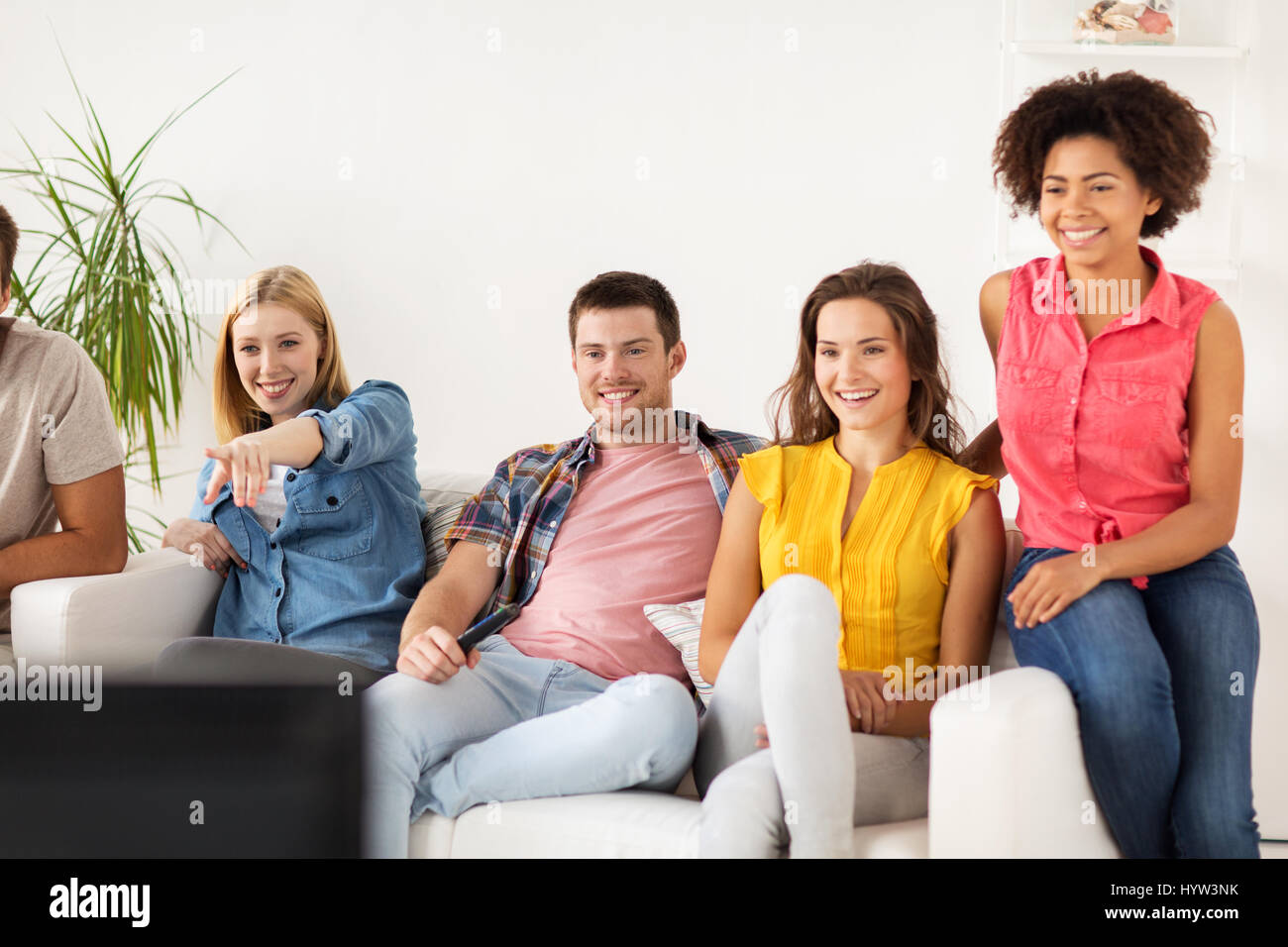 happy friends with remote watching tv at home Stock Photo - Alamy