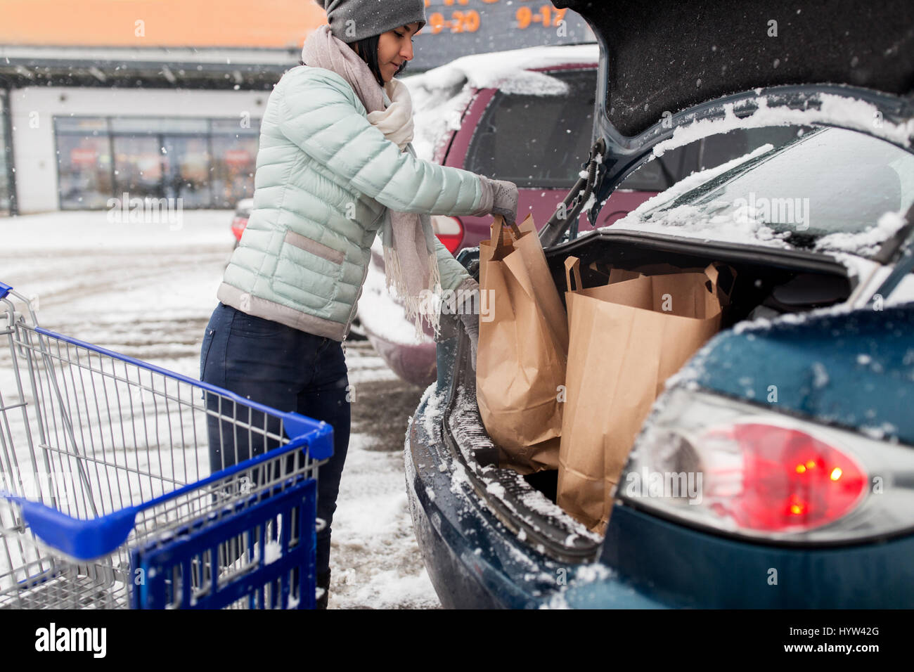 woman loading food from shopping cart to car trunk Stock Photo - Alamy