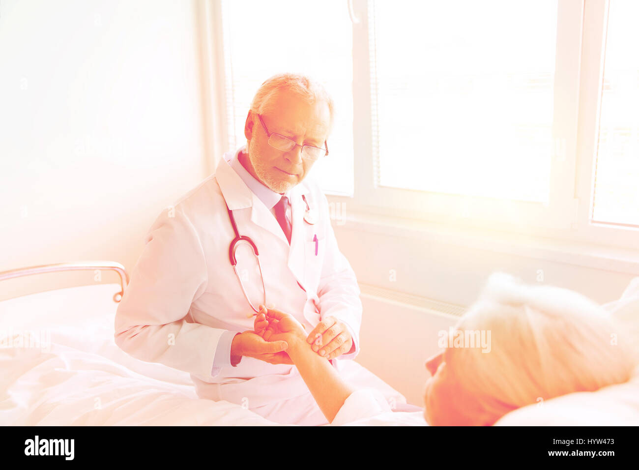 doctor checking senior woman pulse at hospital Stock Photo - Alamy