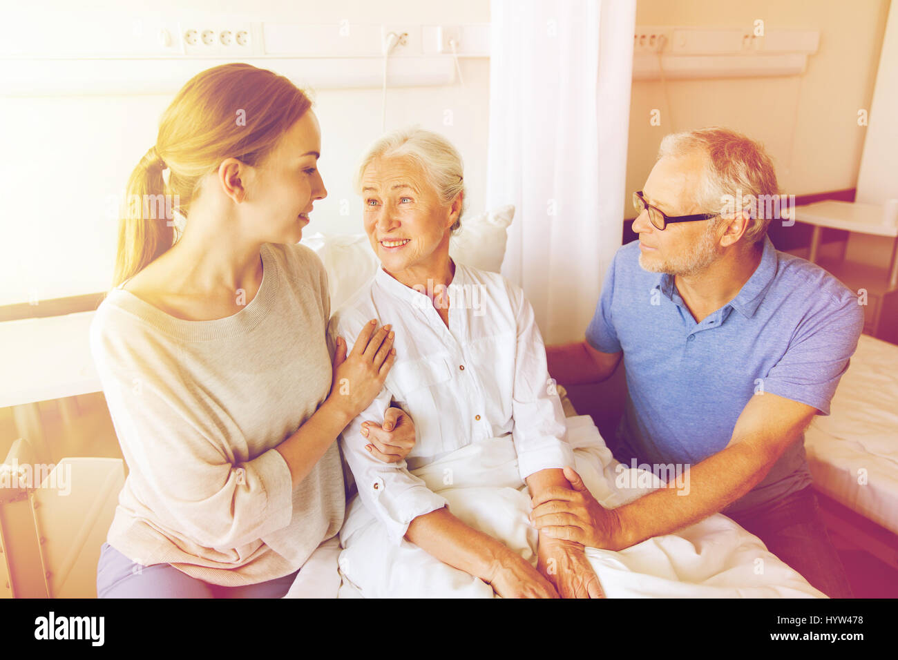 happy family visiting senior woman at hospital Stock Photo - Alamy