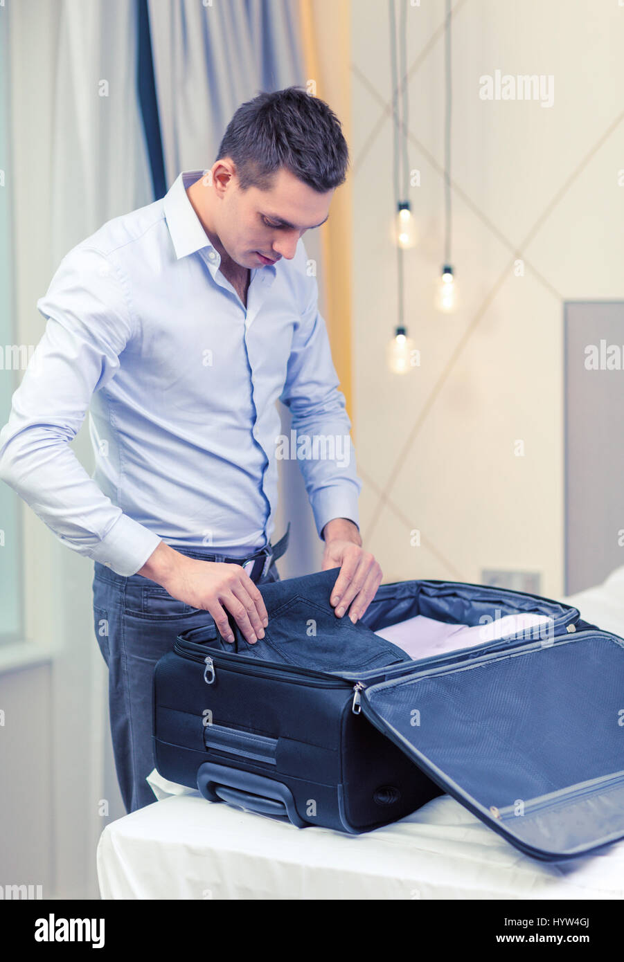 businessman packing things in suitcase Stock Photo - Alamy